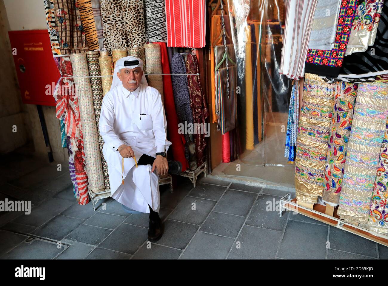 A salesman outside a shop selling fabric in Doha, Qatar Stock Photo - Alamy