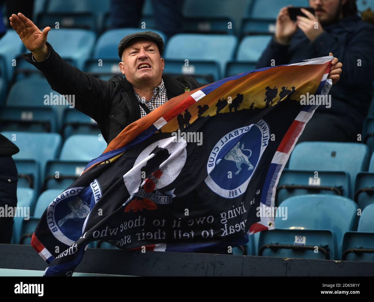 A Millwall fan with a flag gestures towards Stoke City fans Stock Photo ...
