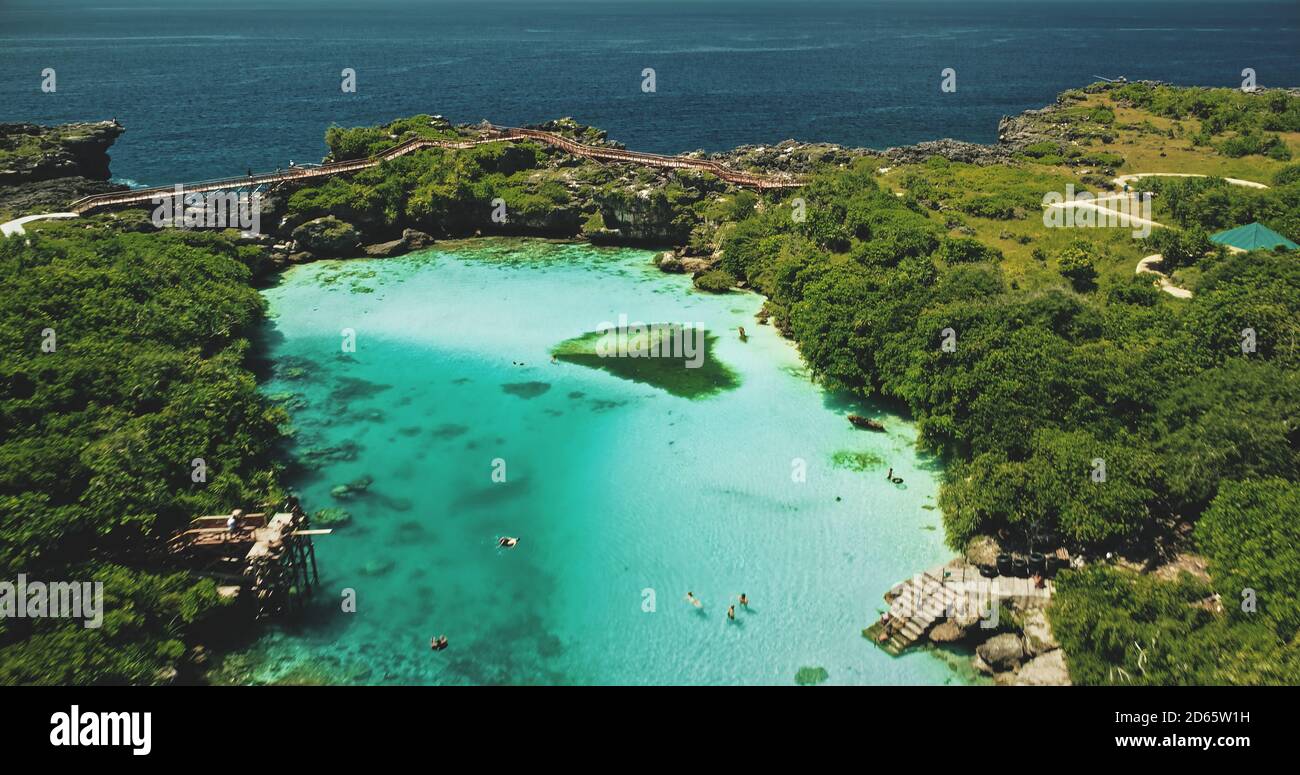 Salt water lake at sea bay with green cliff shore aerial view of Sumba ...