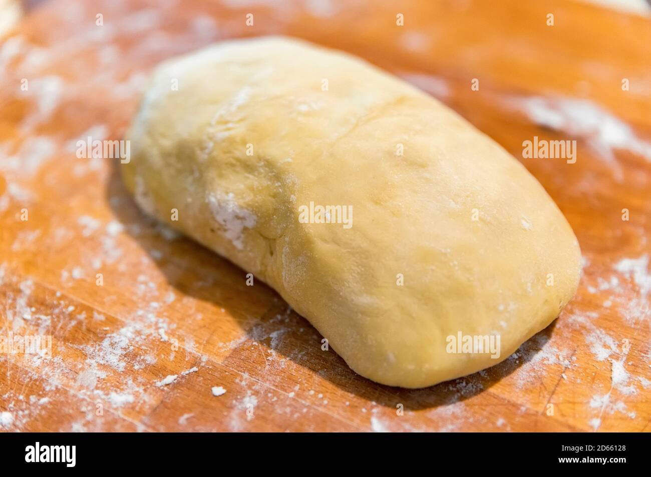 Raw dough covered with flour on a wooden cutting board Stock Photo - Alamy