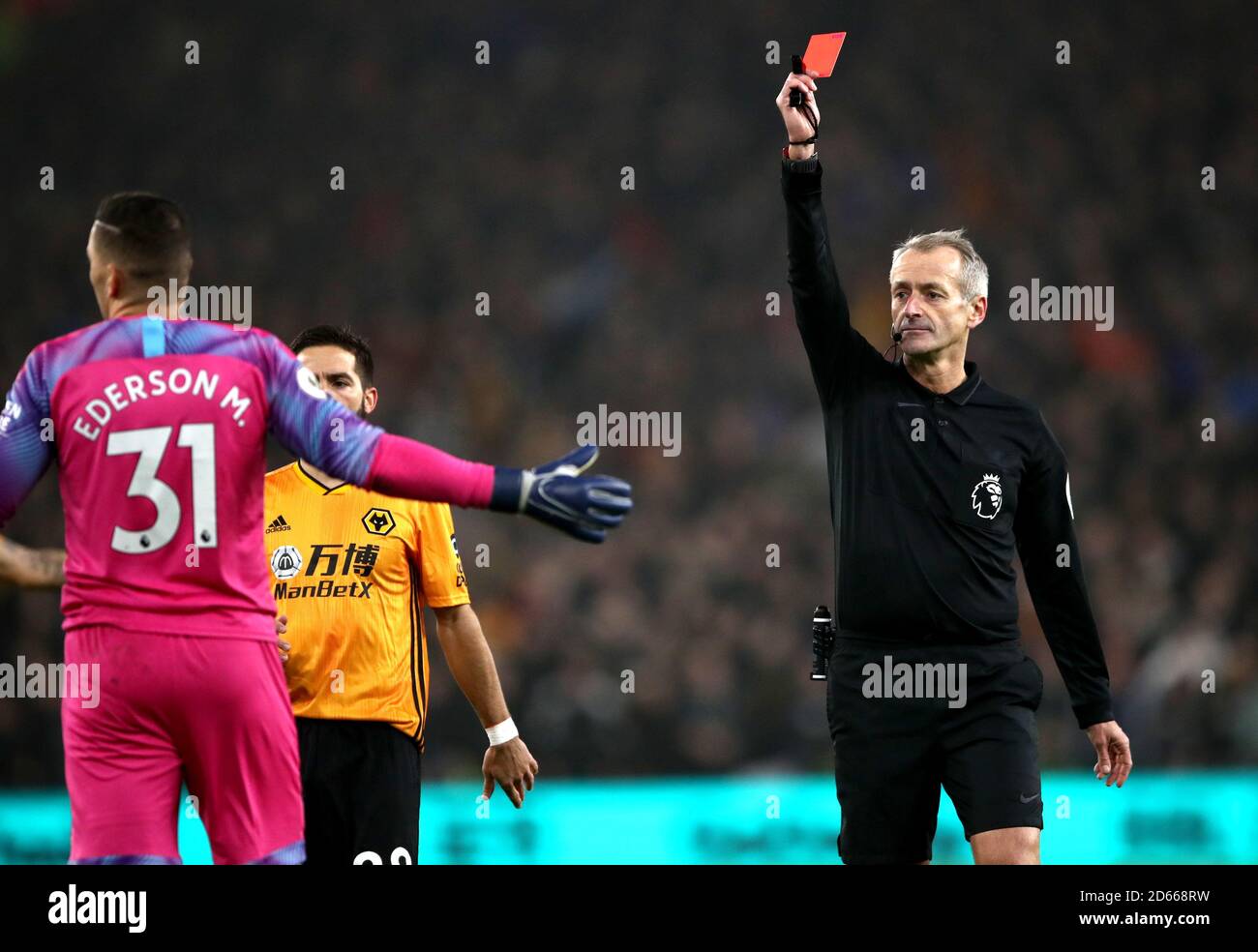 Referee Martin Atkinson shows Manchester City goalkeeper Ederson a red ...