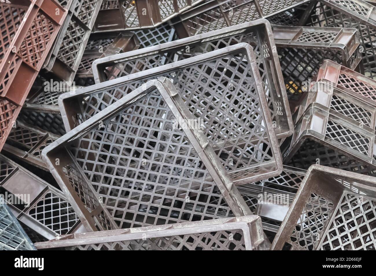 Pile of used grey plastic cargo packaging crates background. Close up ...