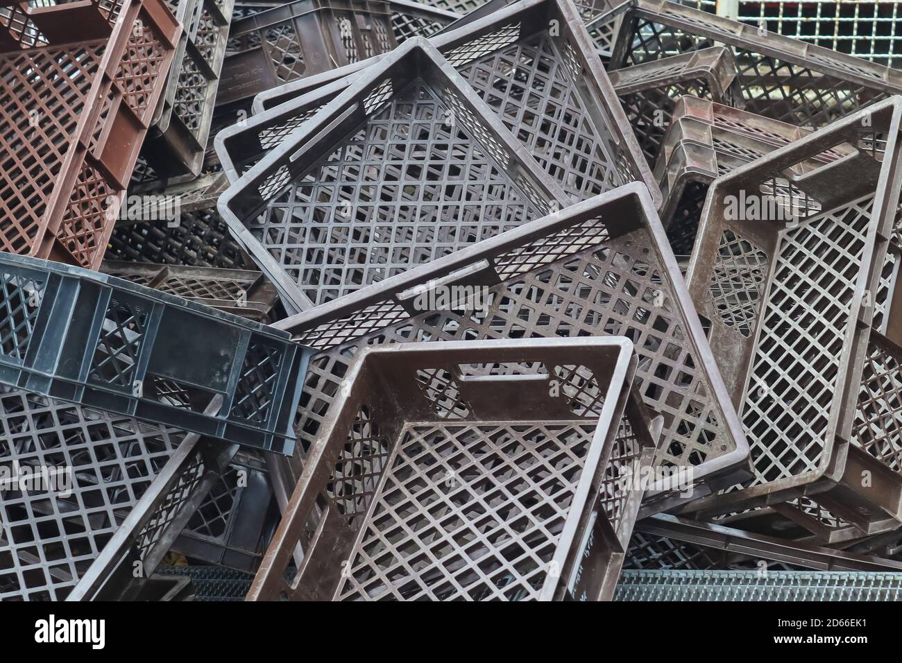 Pile of used grey plastic cargo packaging crates background. Close up ...