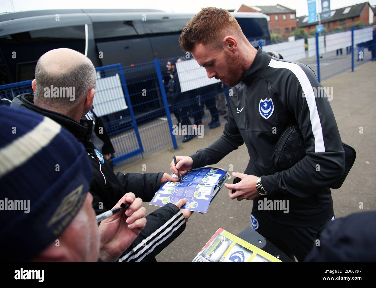 Portsmouth's Tom Naylor (right) signs an autograph for fans outside of ...