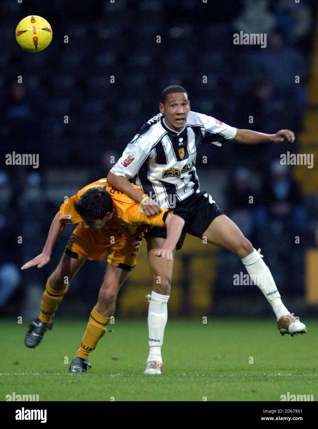 Notts County's Kelvin Wilson heads the ball away from Cambridge United ...