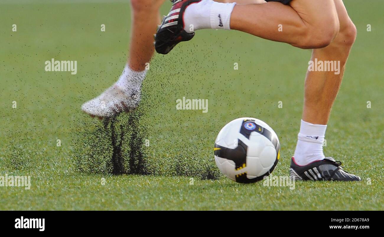 Material from the artificial pitch is kicked up as Fulham players train ...