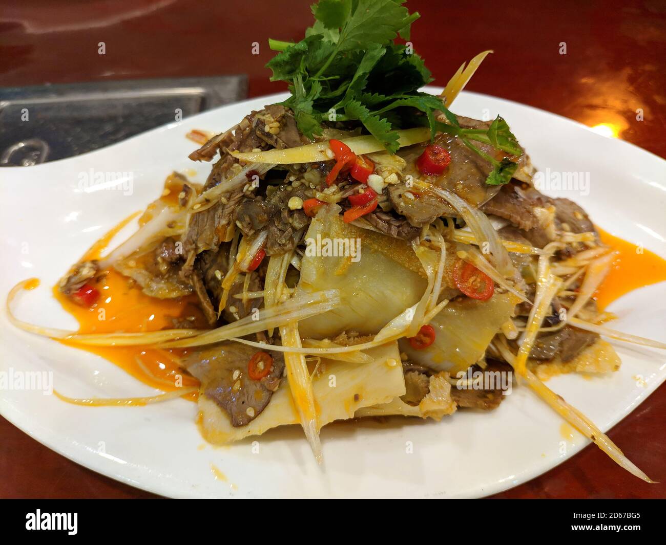 sliced beef and ox tongue in chili sauce in the white plate for eating ...