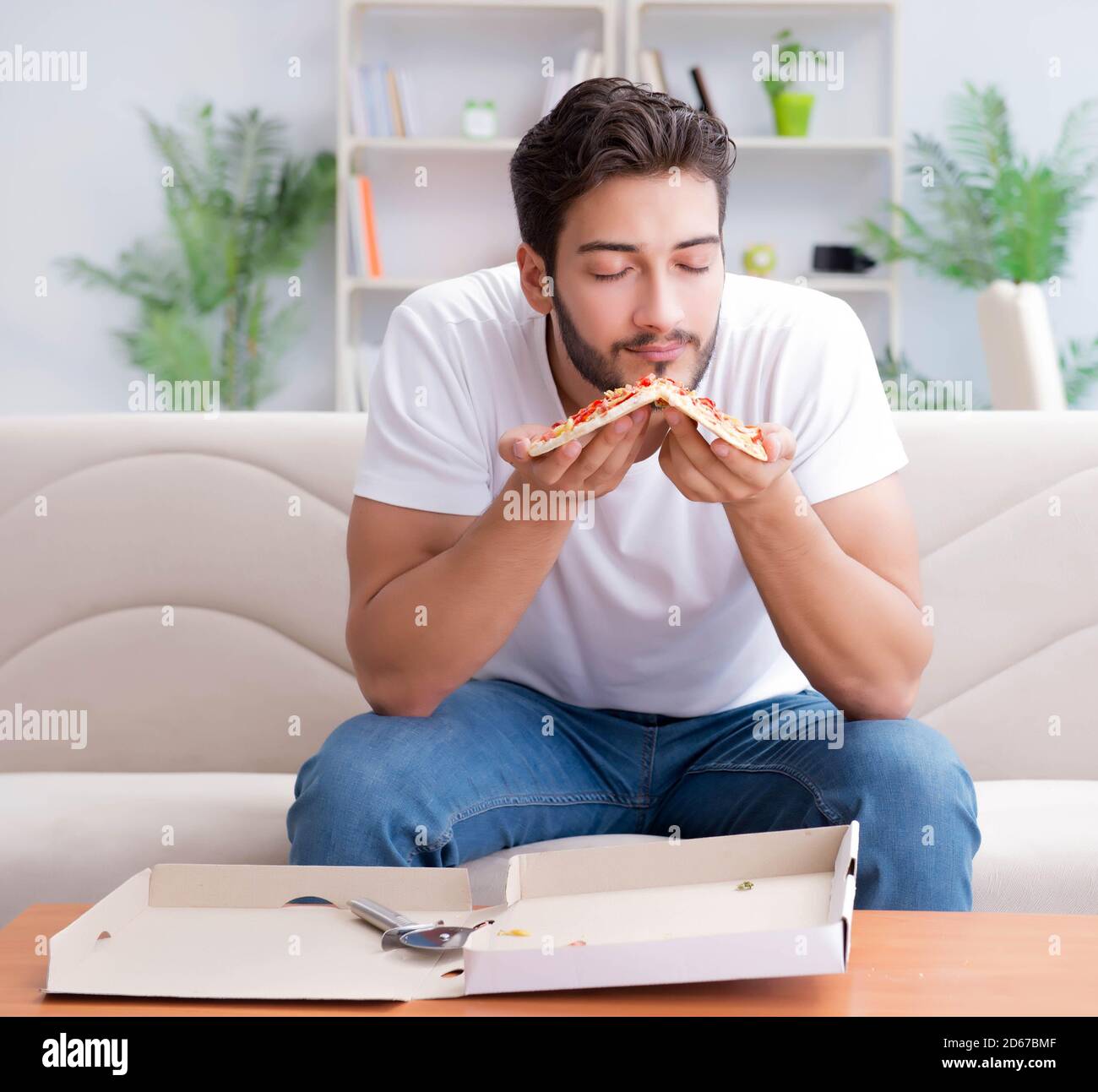The man eating pizza having a takeaway at home relaxing resting Stock ...