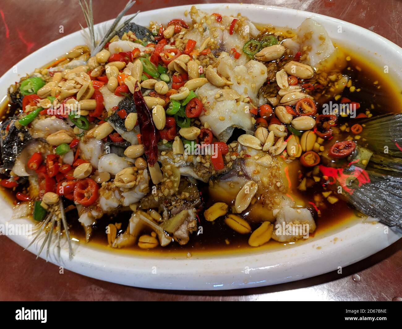 fresh braised fish with colorful peppers and ripe peanuts in the soup ...