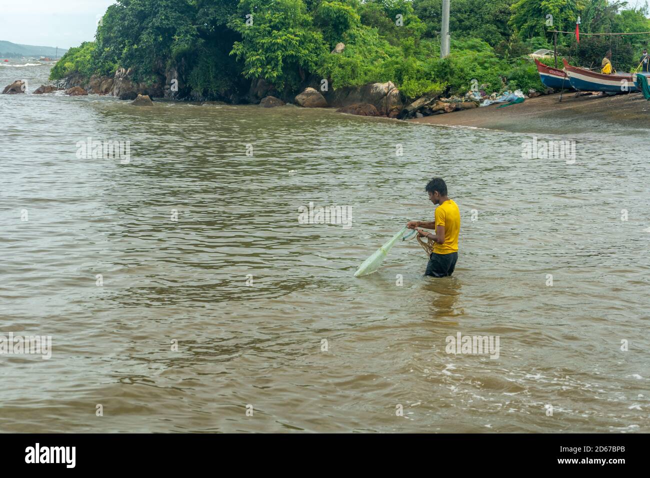 THANE, INDIA - Oct 01, 2020: fisherman washing fishing net on beach ...