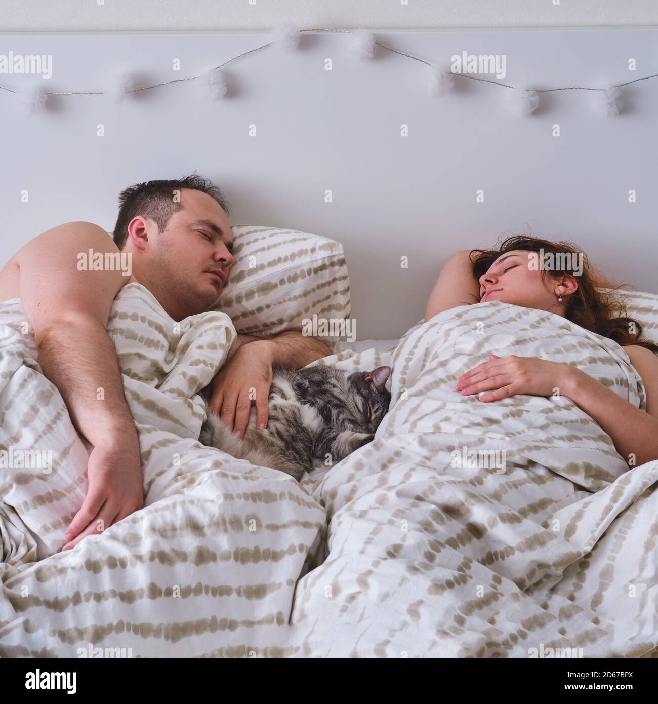 Couple sleeping on the bed with cat, real lifestyle Stock Photo - Alamy