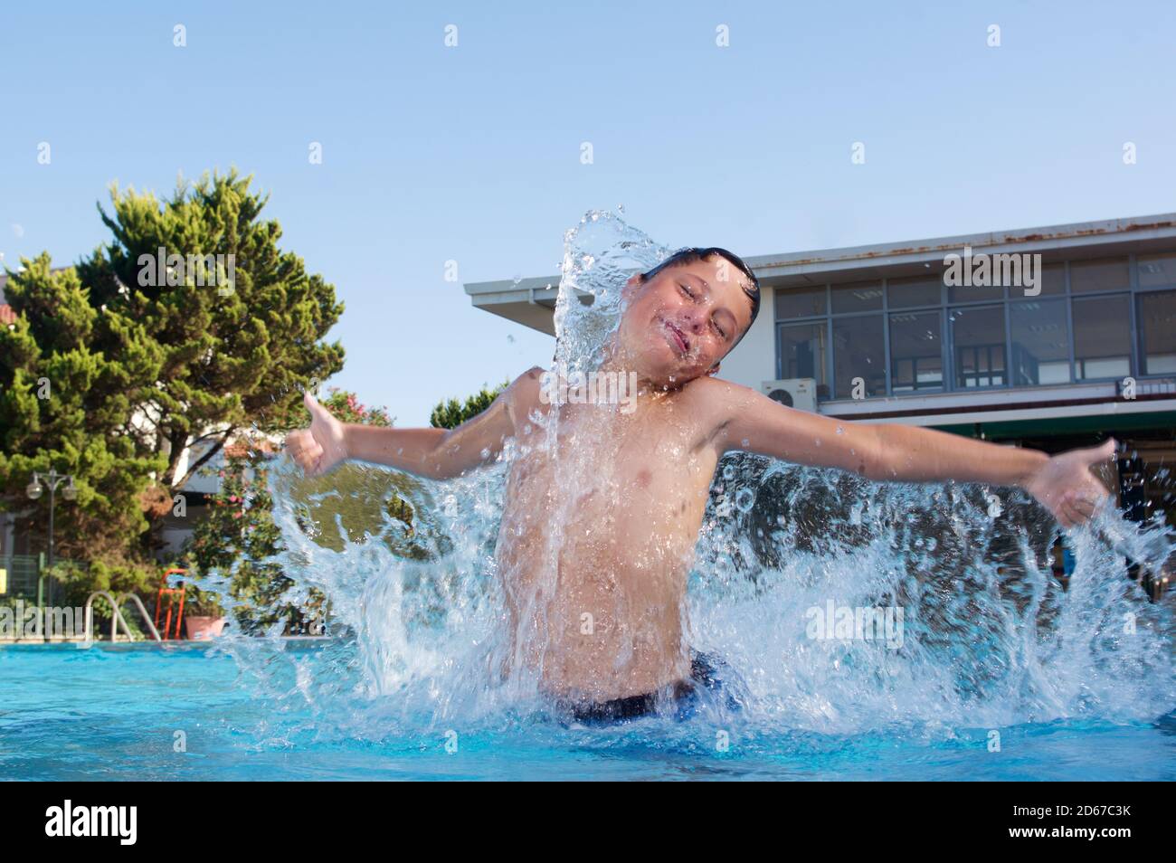 Boy emerging from swimming pool with a splash Stock Photo - Alamy