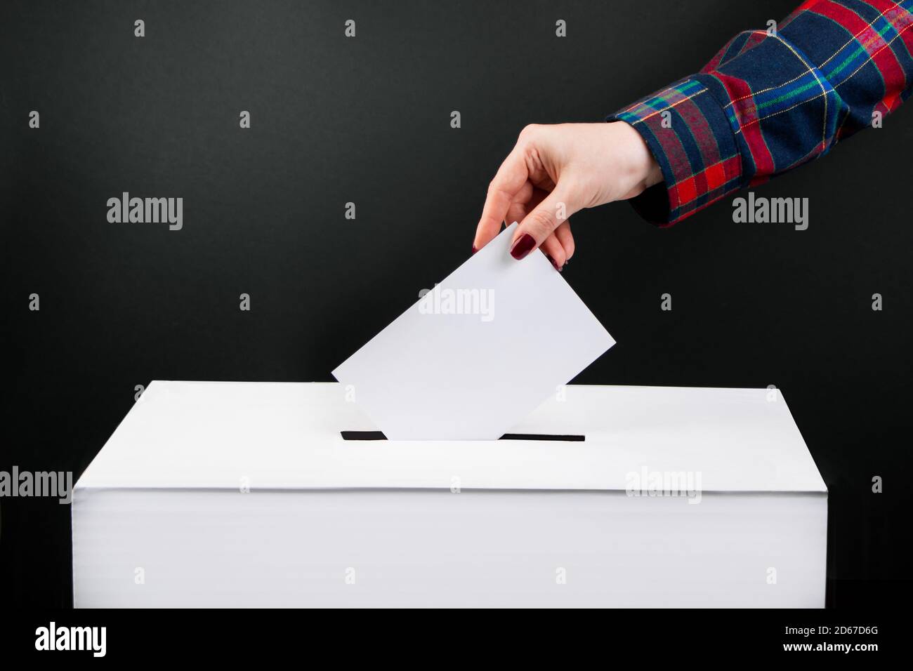 Elections and voting concept. Woman puts ballot paper in box on a black ...