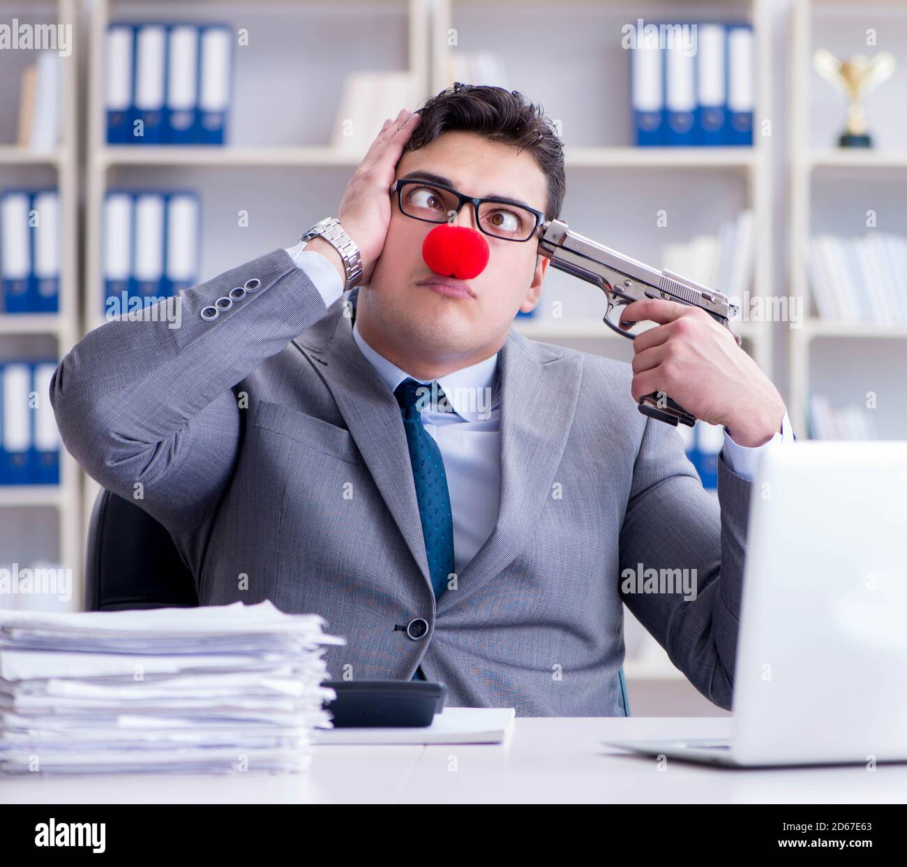 Clown businessman working in the office frustrated commiting suicide ...