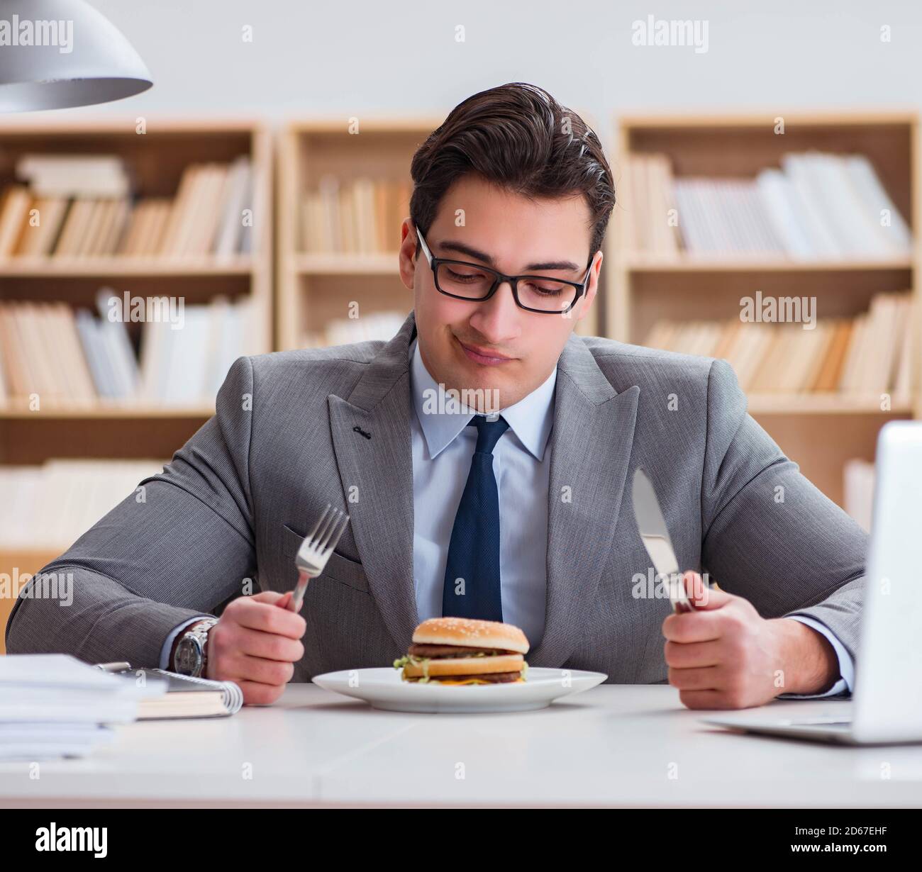 The hungry funny businessman eating junk food sandwich Stock Photo - Alamy