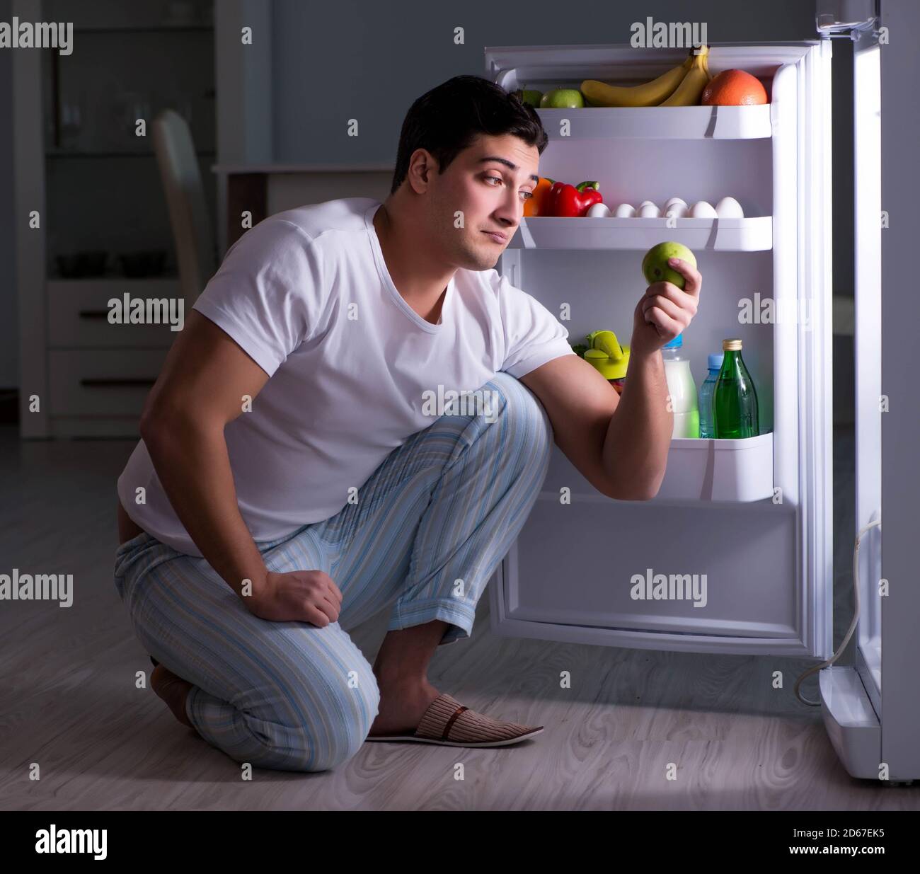 The man at the fridge eating at night Stock Photo - Alamy