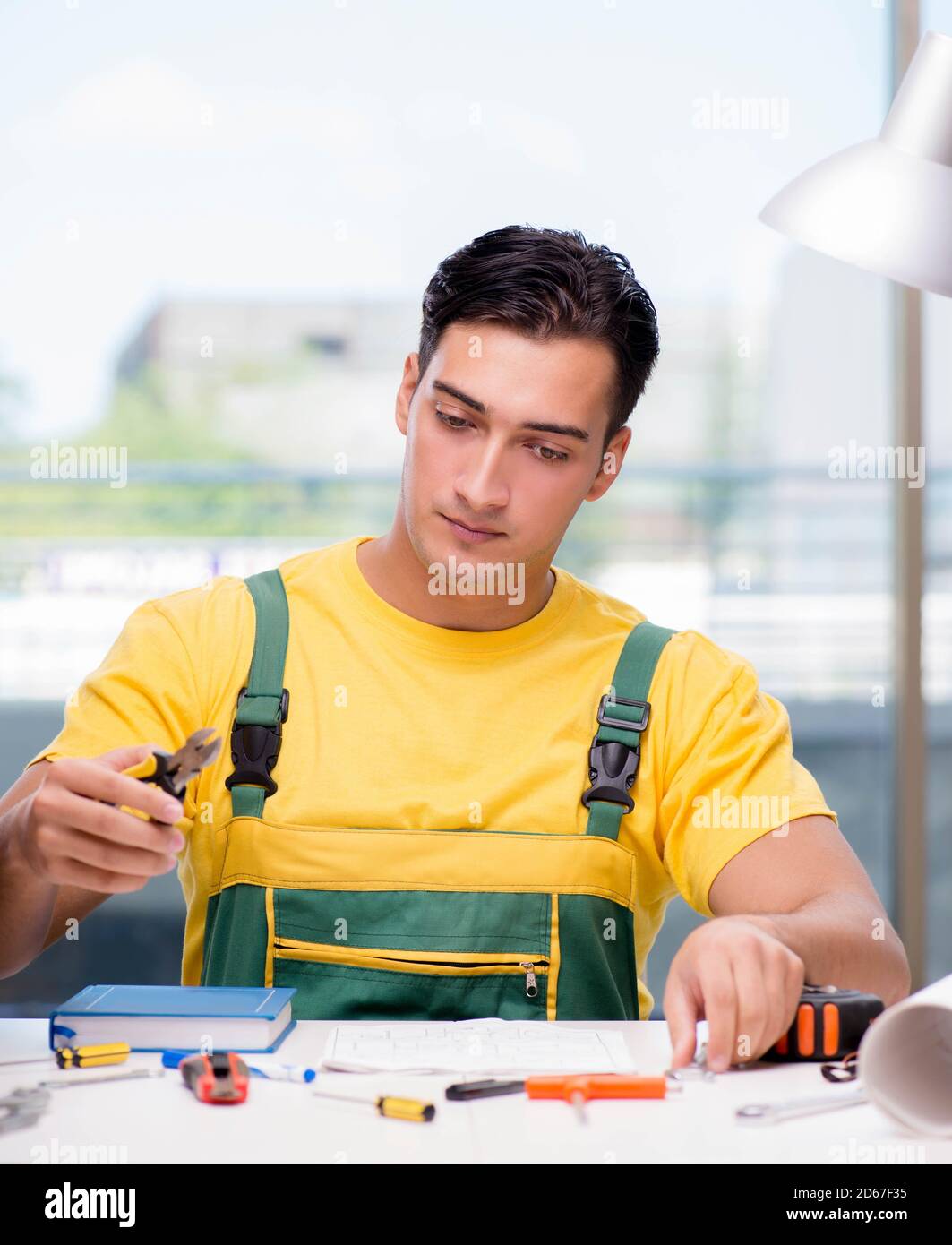The construction worker sitting at the desk Stock Photo - Alamy
