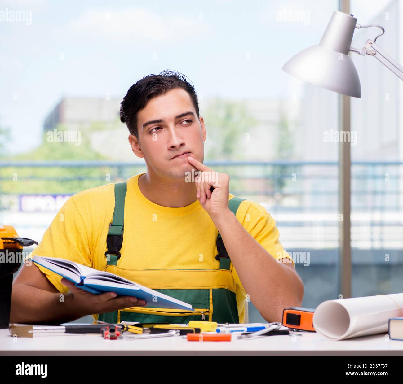 The construction worker sitting at the desk Stock Photo - Alamy