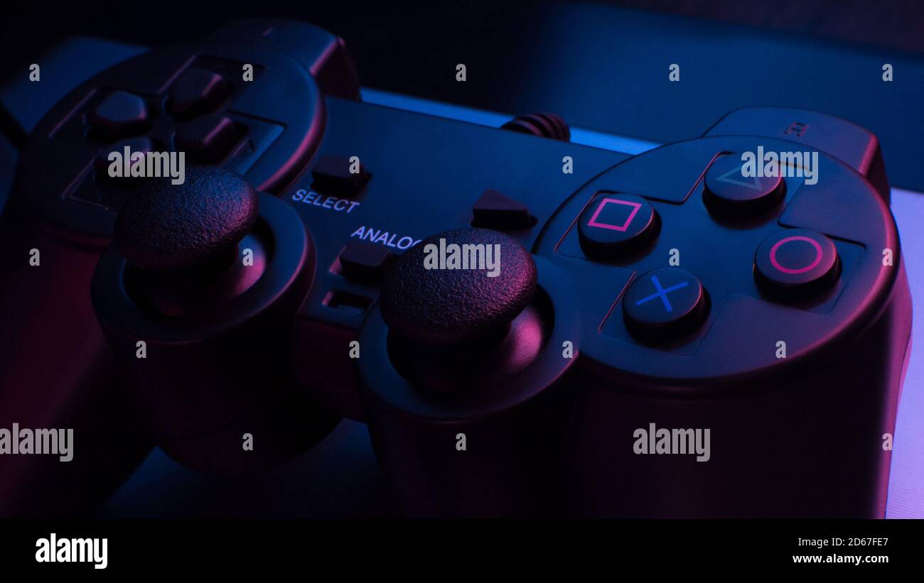 Game controller under blue and red lights in a dark room Stock Photo ...