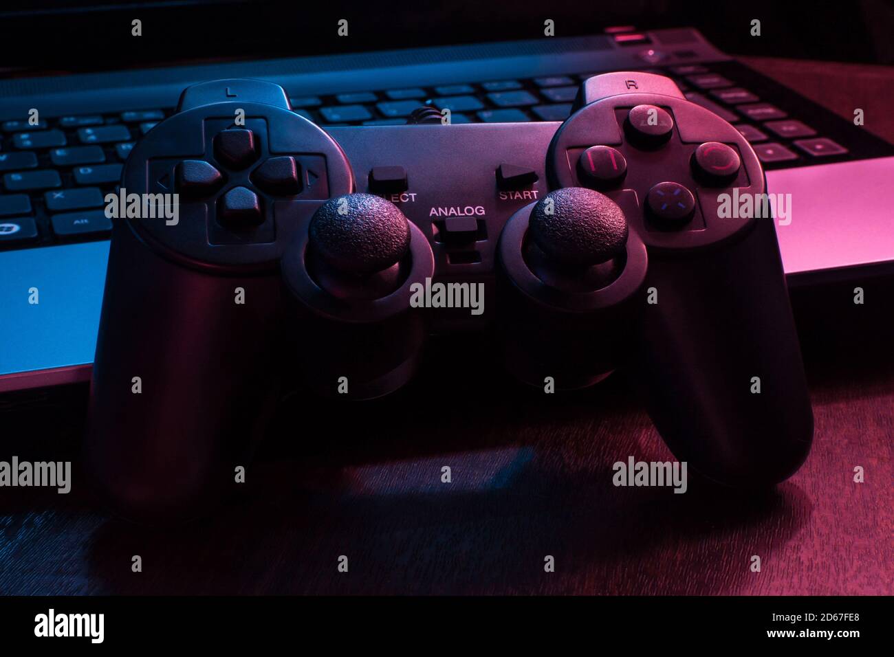 Game controller under blue and red lights in a dark room Stock Photo ...