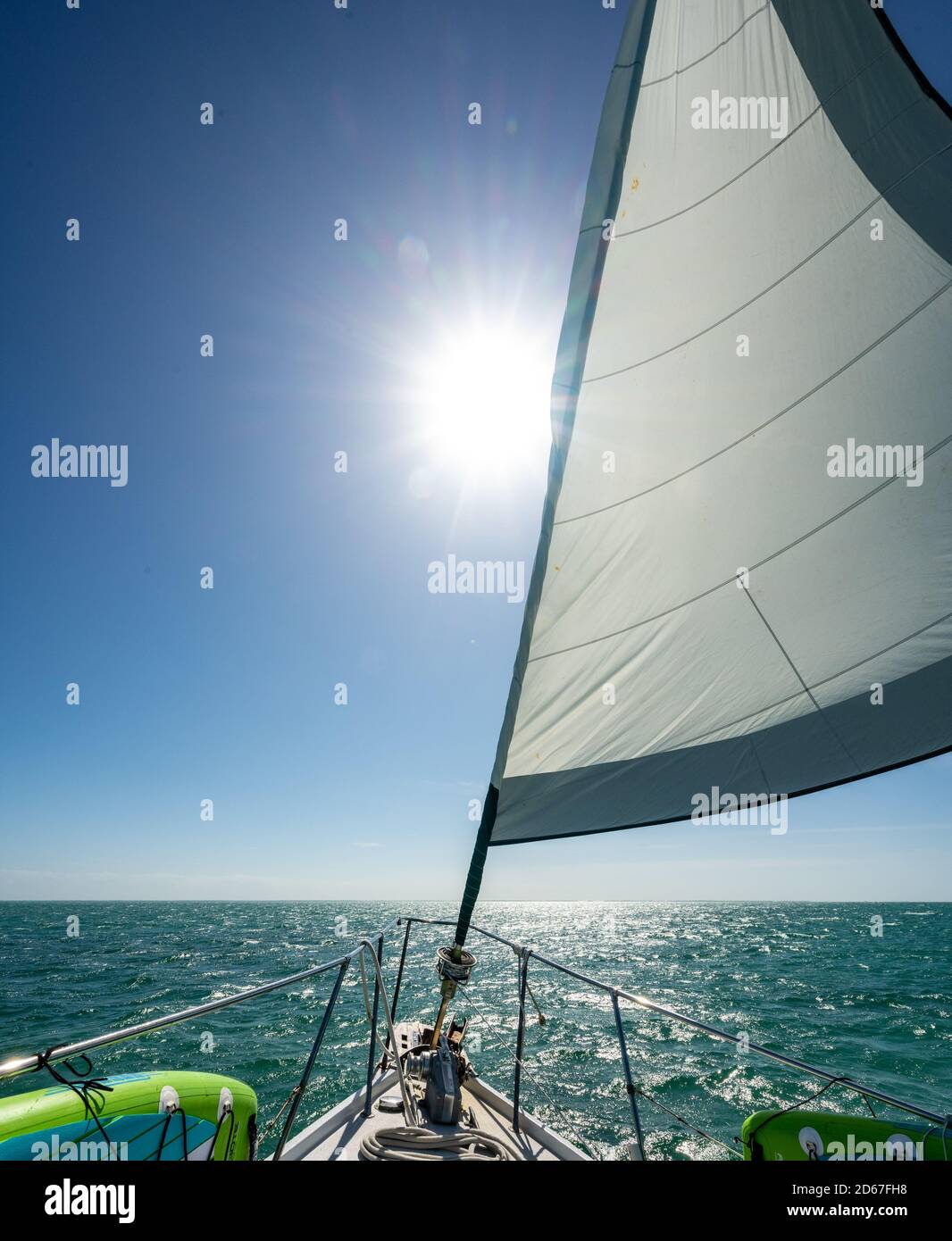 Sunburst Behind Unfiurled Sail moving across Biscayne Bay Stock Photo ...