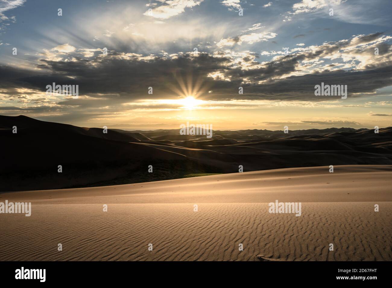 Sunburst Over Layers of Sand Dunes in Colorado Stock Photo - Alamy