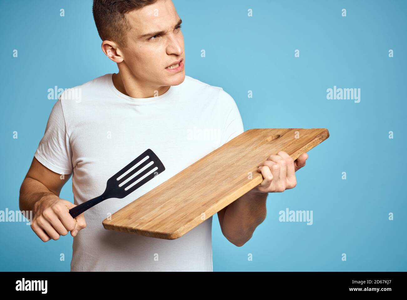 energetic guy with wooden kitchen board and spatula fun emotions Stock ...