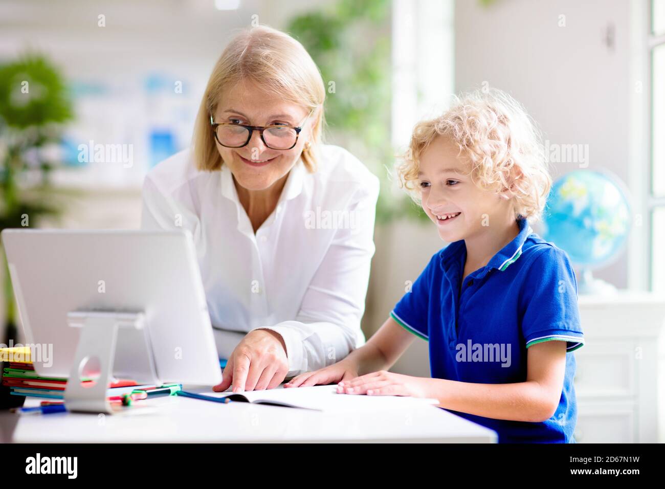 Online remote learning. School kids with computer having video ...