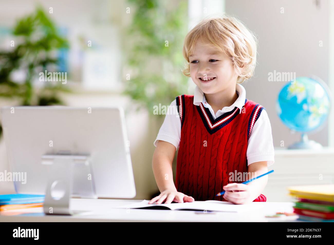 Online remote learning. School kids with computer having video ...