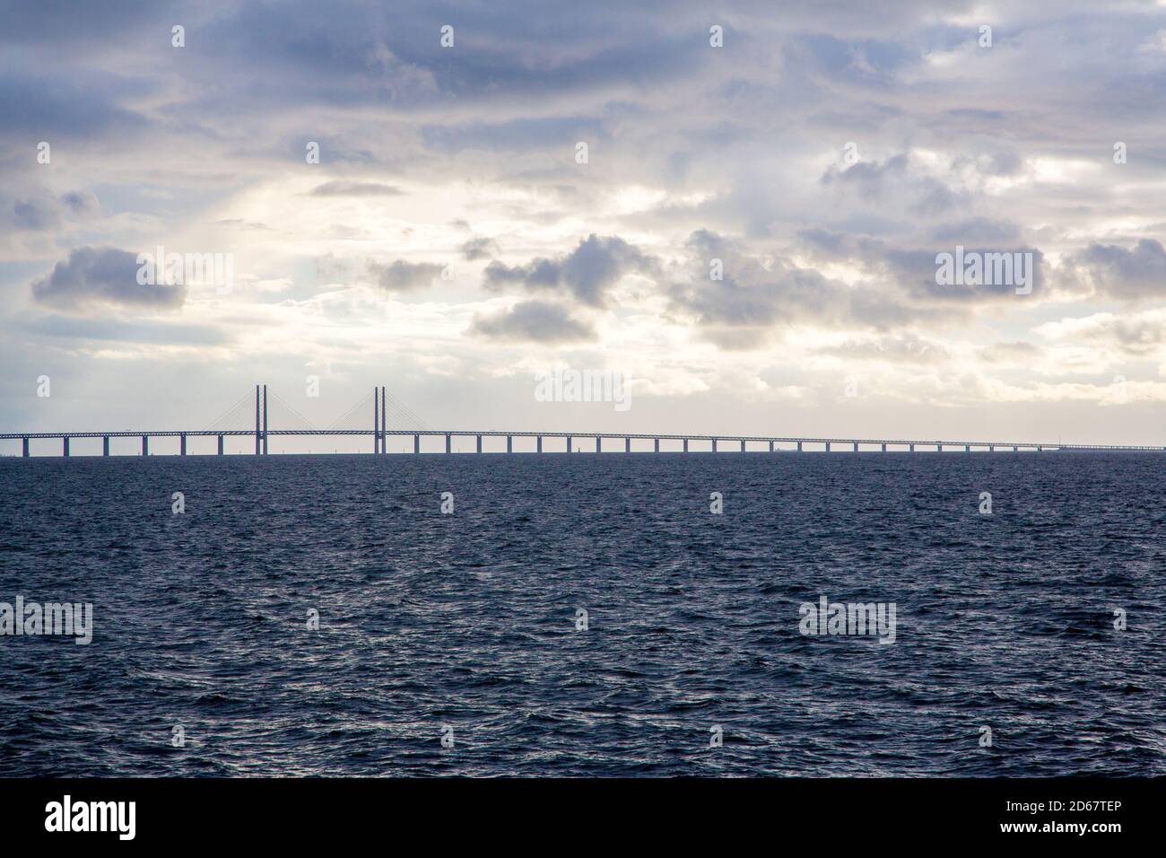 Ocean gleaming under the rainy and cloudy sky with the Oresund Bridge ...