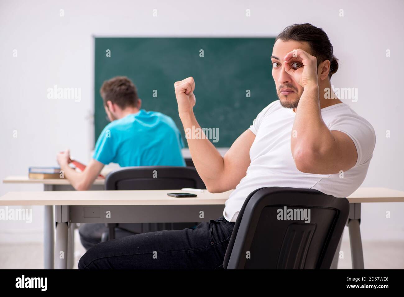 Male pupils in bullying concept in the classroom Stock Photo - Alamy