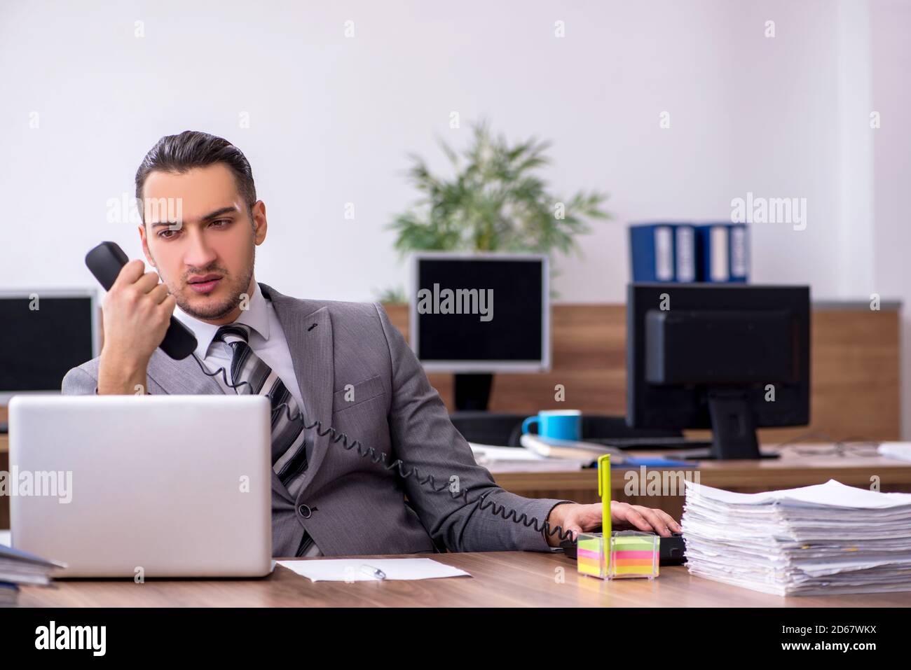 Young male employee working in the office environment Stock Photo - Alamy