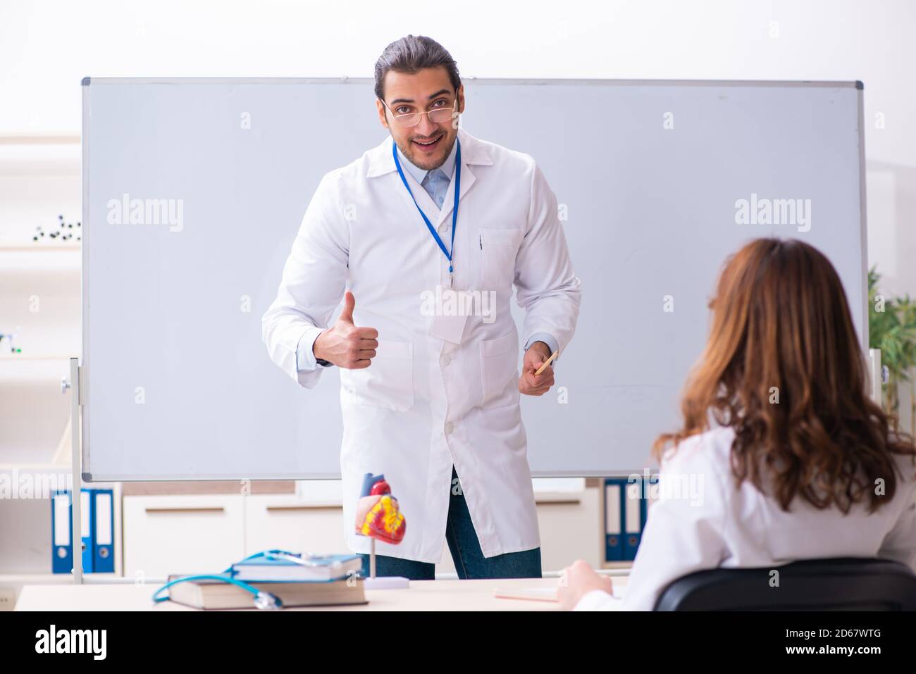 Young male doctor cardiologist and female student in the classroom ...