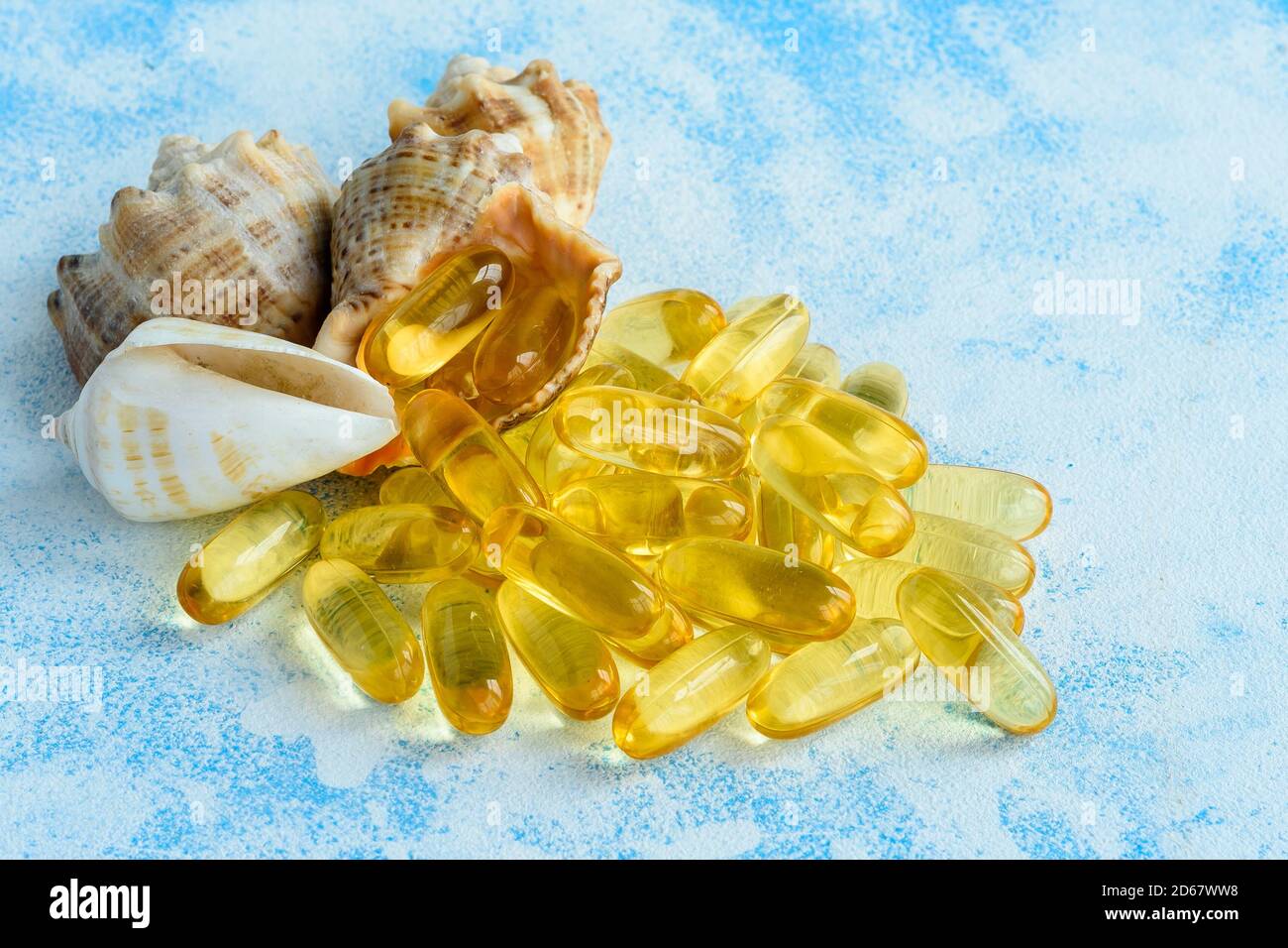 Golden fish oil capsules on a blue background - the concept of health ...
