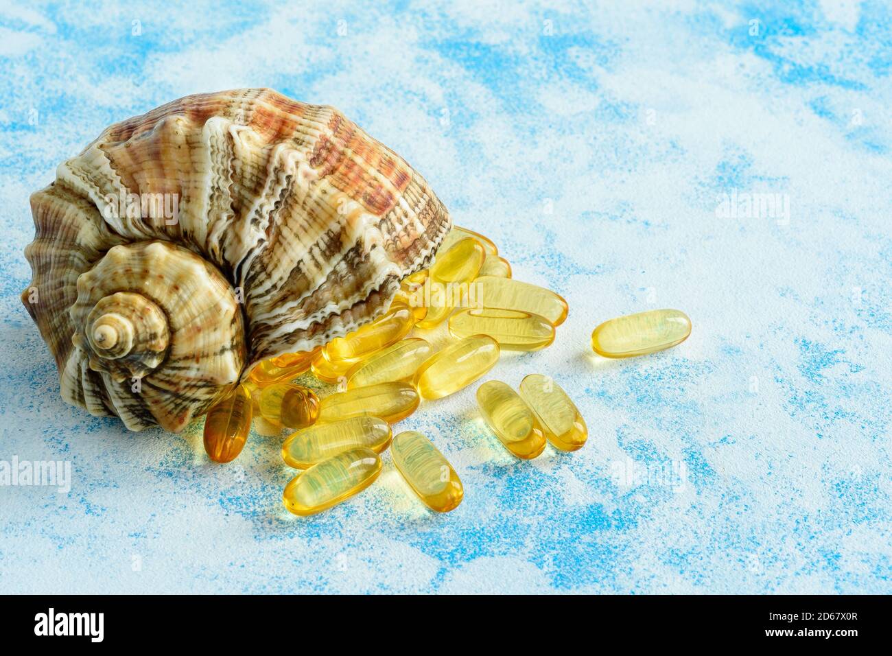 Golden fish oil capsules on a blue background - the concept of health ...