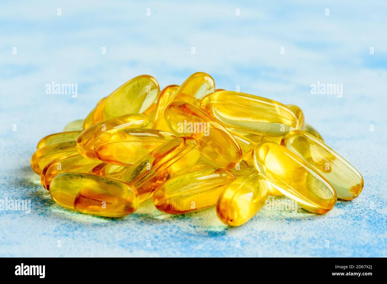 Fish oil capsules on a blue background - omega 3 vitamins and health ...