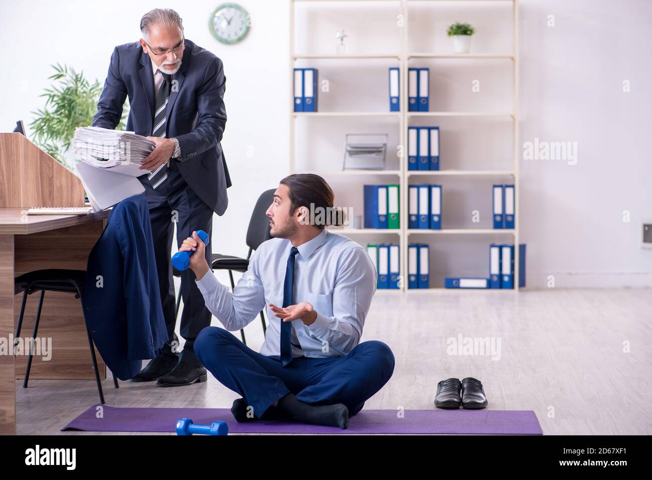 Two employees doing physical exercises at the workplace Stock Photo - Alamy