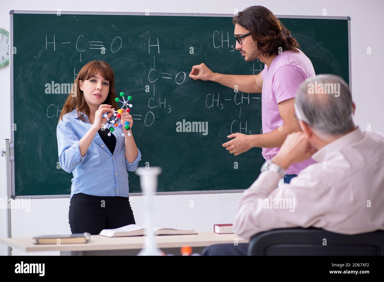Old teacher and two students in the classroom Stock Photo - Alamy