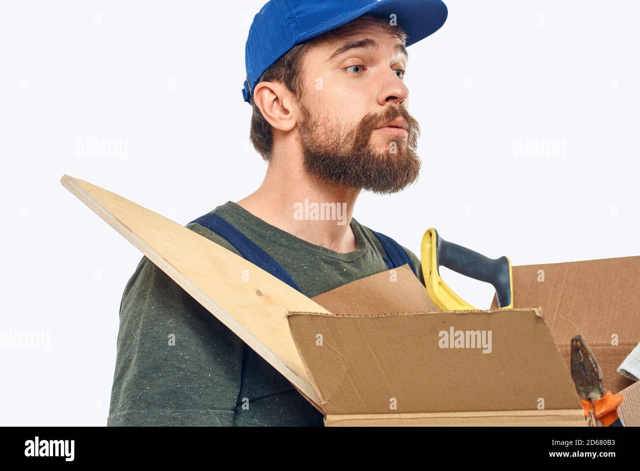 Worker man in uniform with a box in his hands tools delivery service ...
