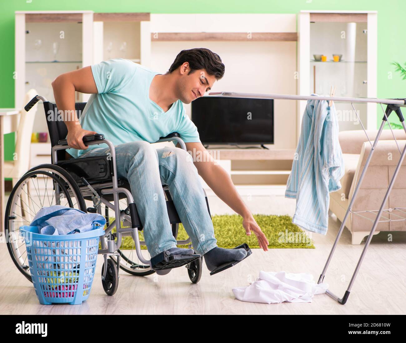 The disabled man on wheelchair doing laundry Stock Photo - Alamy