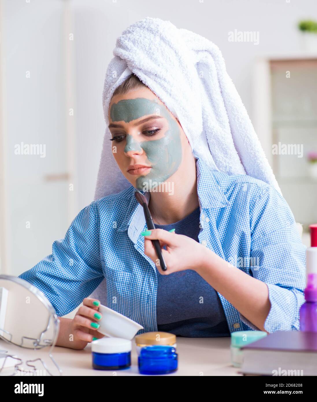 The woman applying clay mask with brush at home Stock Photo - Alamy