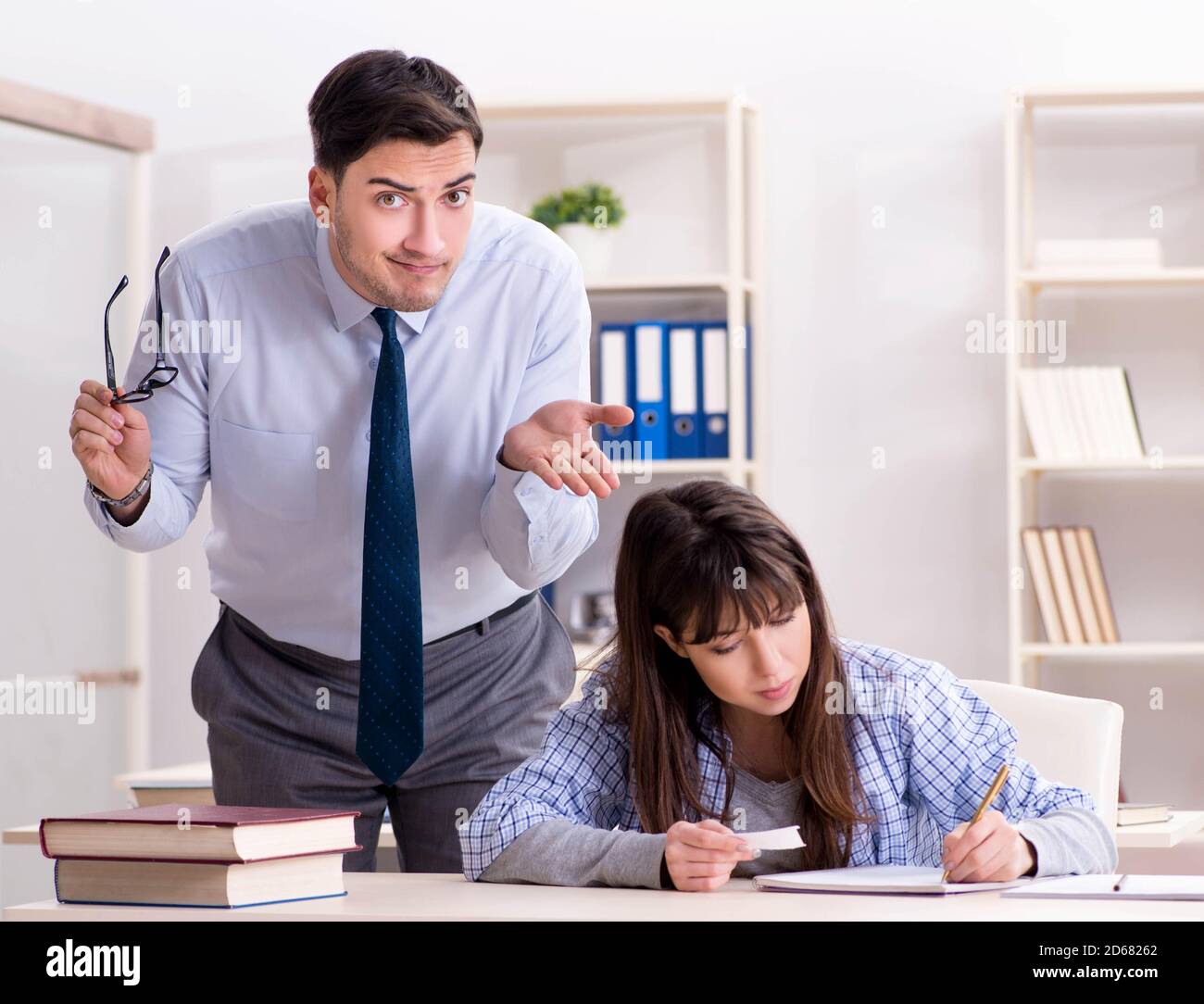 The male lecturer giving lecture to female student Stock Photo - Alamy