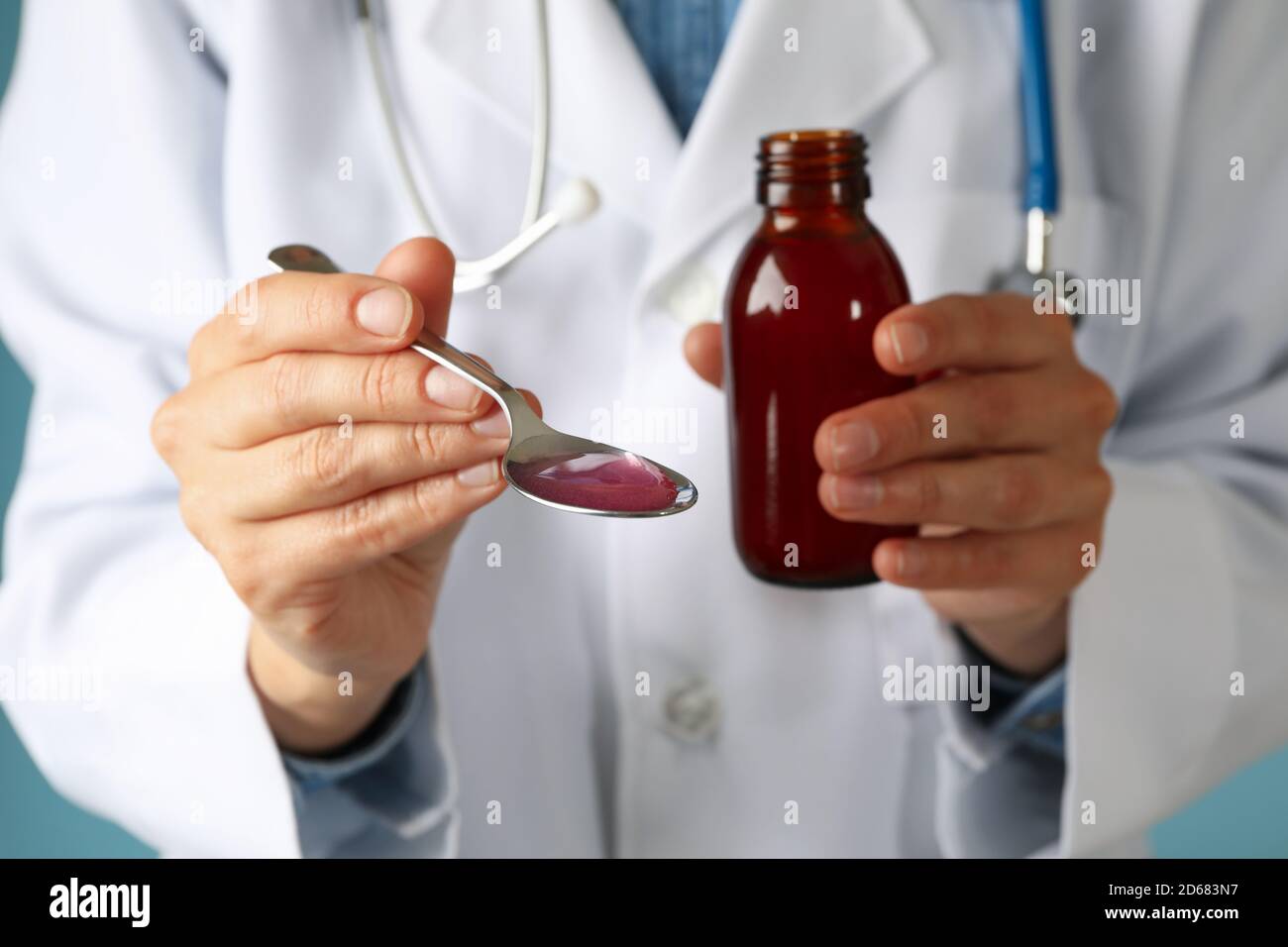 Doctor hold bottle and spoon with syrup, close up Stock Photo - Alamy