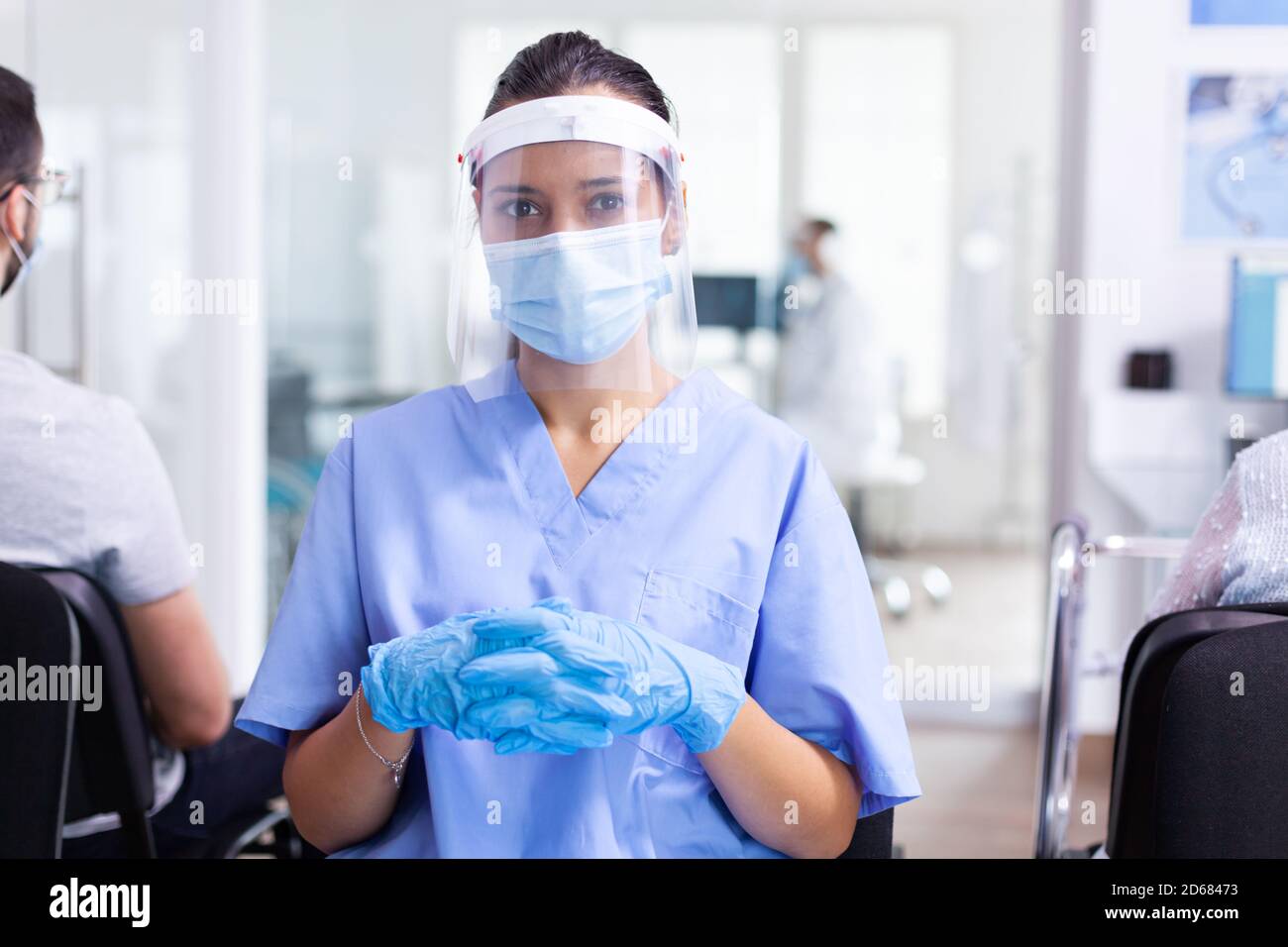 Medical staff in waiting area of hospital wearing surgical face mask as ...