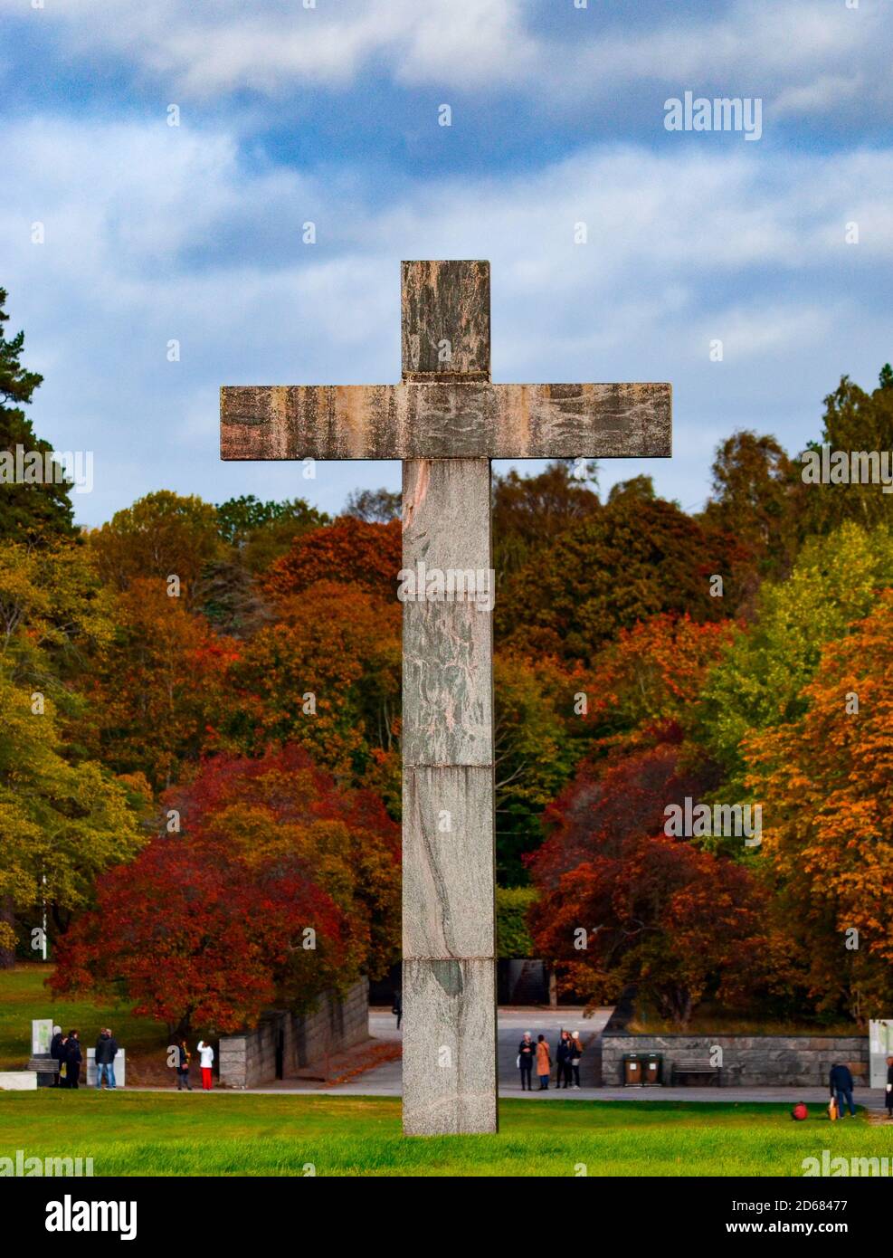 Vertical shot of a cross with colorful trees in the background Stock ...