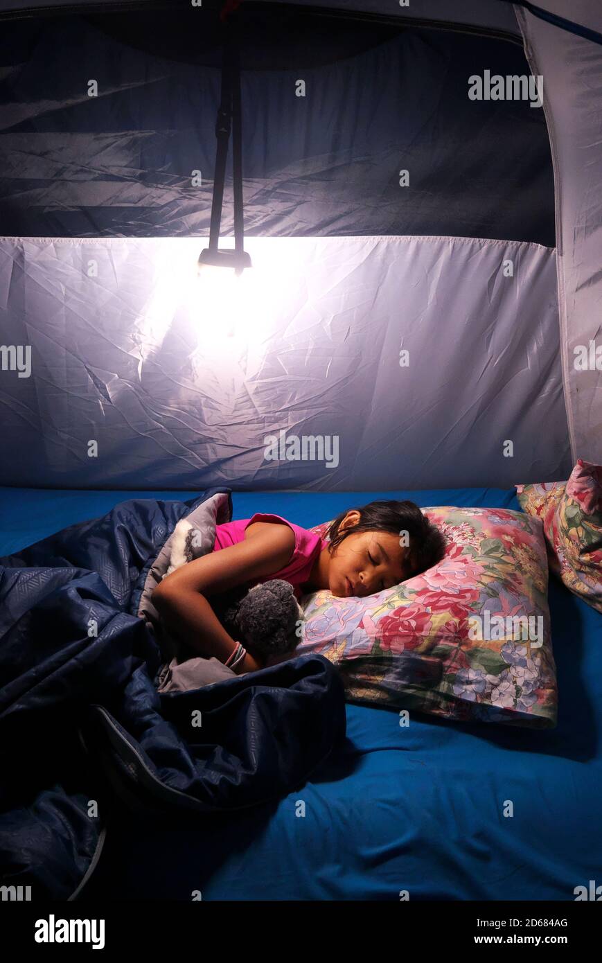 Little Metis girl sleeping soundly in a camping tent during the ...