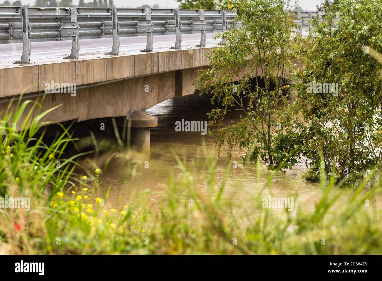 bridge on muddy water of a raging river Stock Photo - Alamy