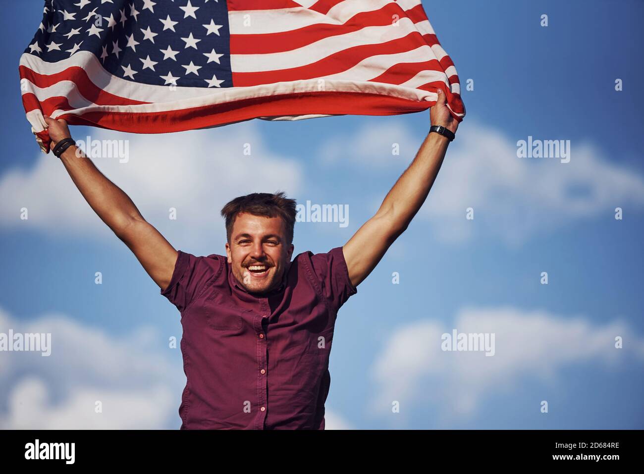 Patriotic happy man waving American Flag against cloudy blue sky Stock ...