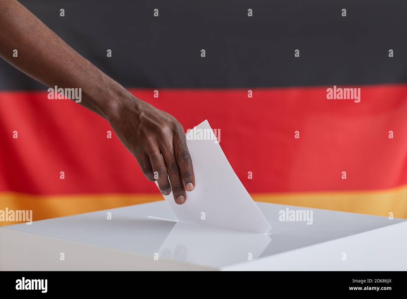 Close-up of African man putting ballot into voting box against the ...