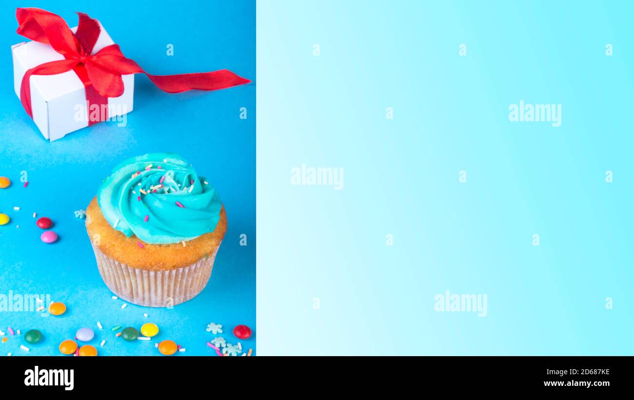 composition of cupcake with present gift box with red ribbon on blue ...